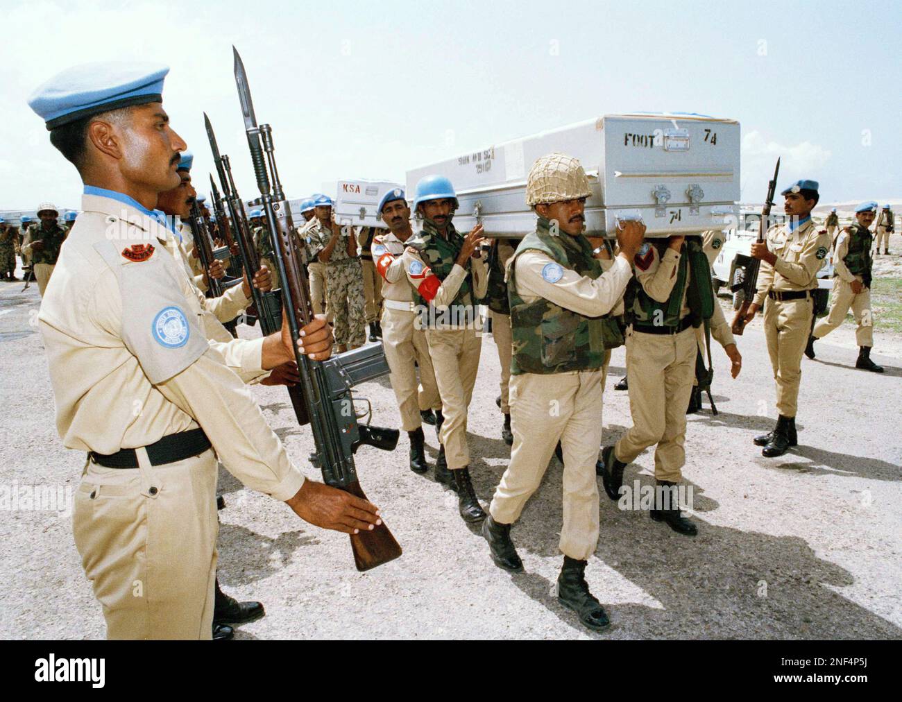 Pakistani soldiers carry the caskets of 23 of their colleagues, covered ...