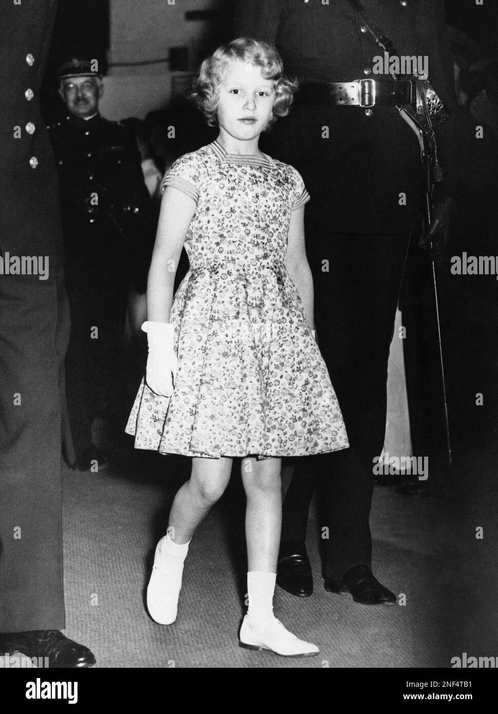 Princess Anne, 7, her white gloves matching shoes and socks, is shown ...