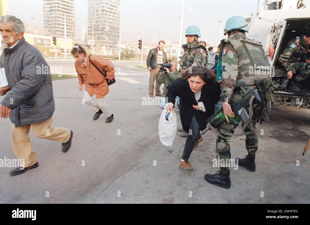 Sarajevo residents run along "Sniper Alley" under the protection of ...