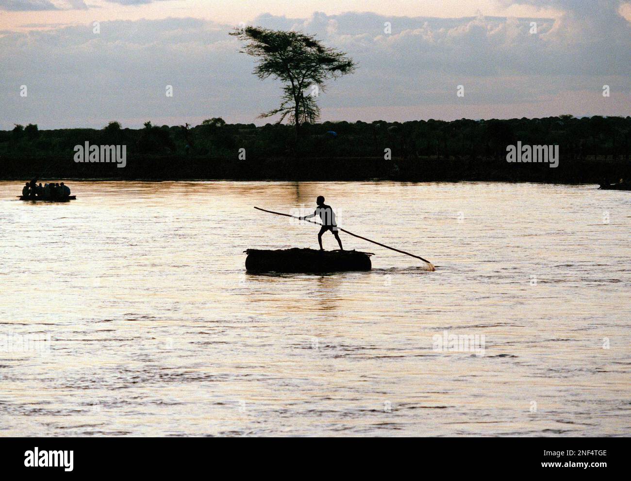 A Somali poles his raft across the Dawa River which marks the border ...