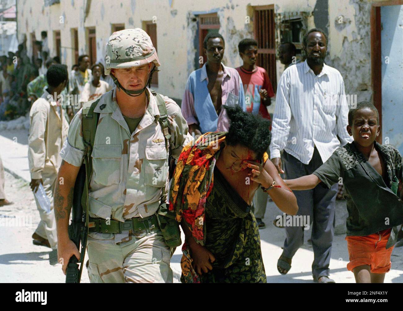 Gunnery Sergeant Leonard Long Henry escorts a Somali woman to a Marine ...