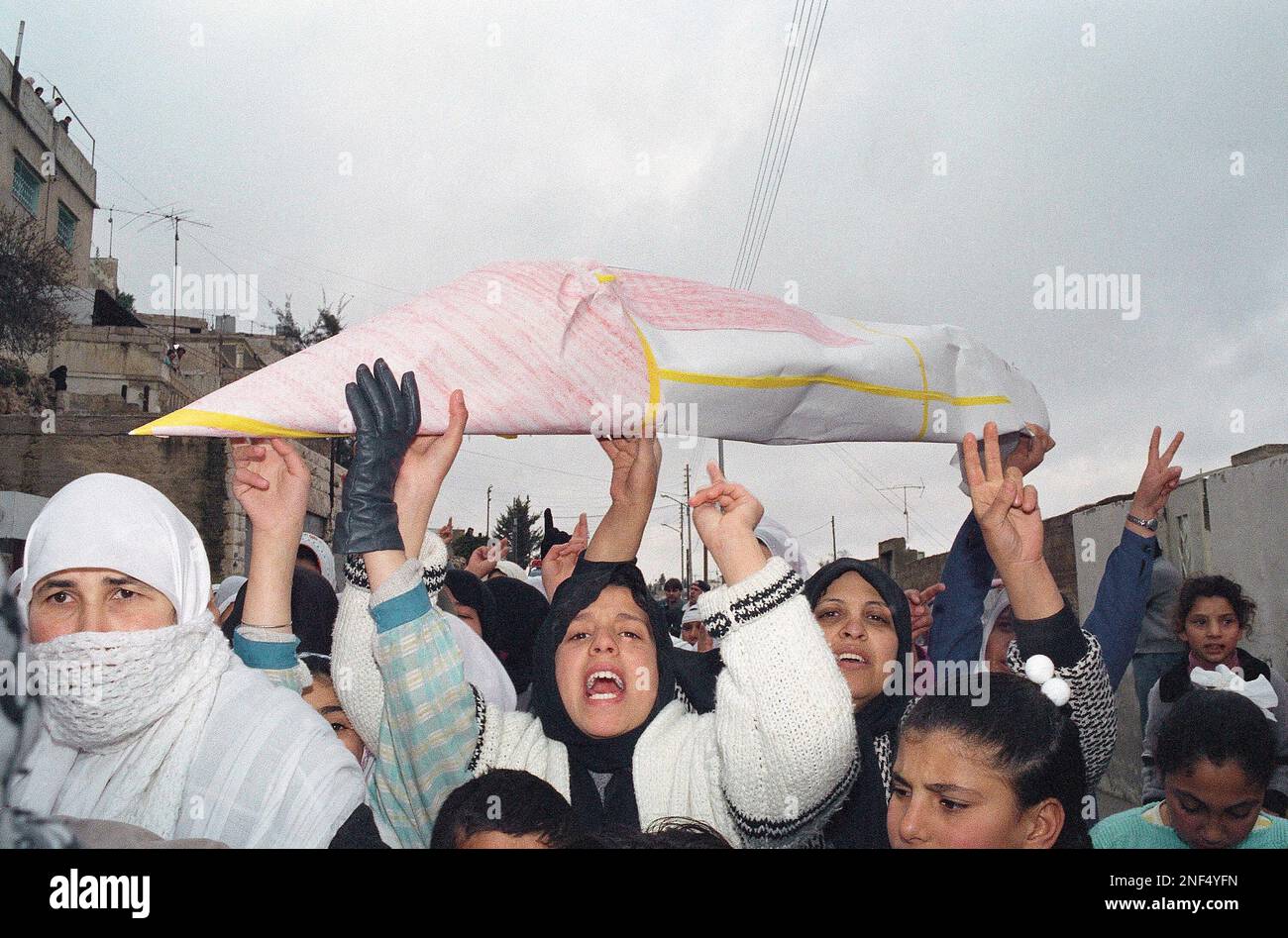 Jordanian demonstrators carry a paper model of a Scud missile overhead ...