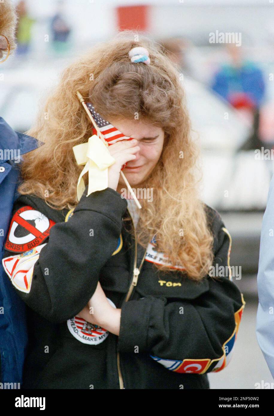 Amy Mason, from Uriah, Alabama, weeps into an American flag as she ...