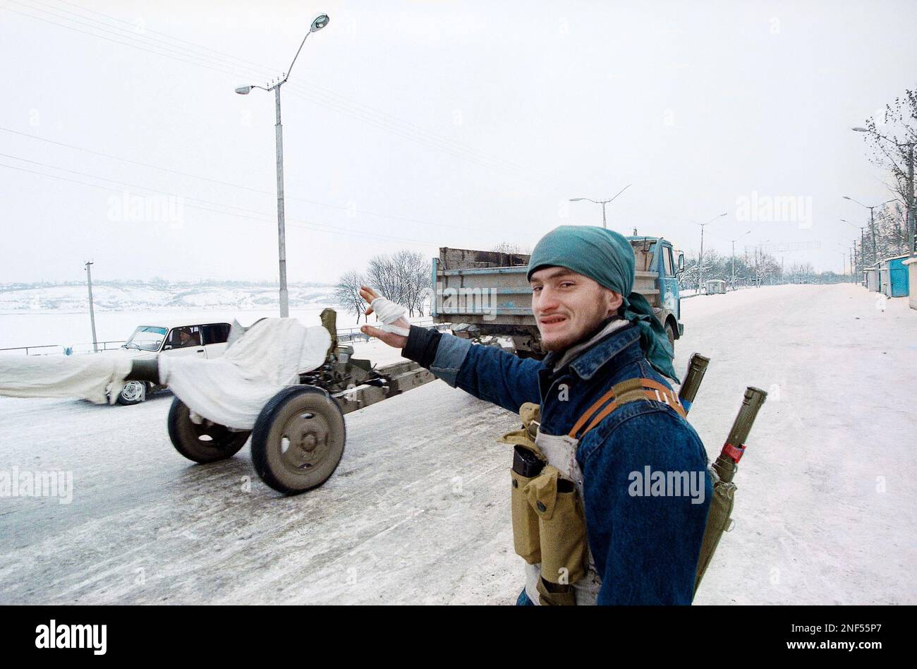 A Chechen fighter waves goodbye to his comrades leaving with a truck ...