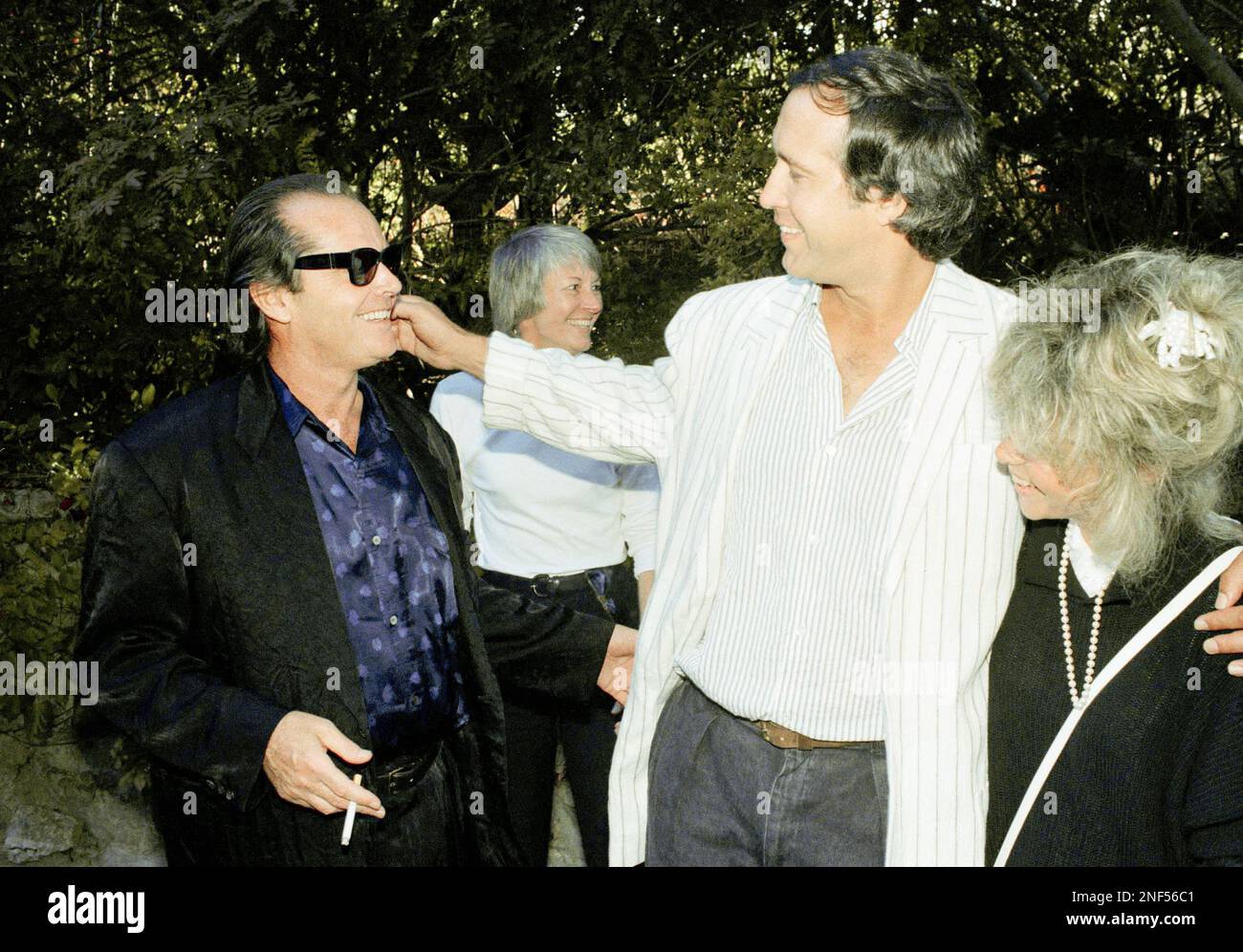 Actor Chevy Chase, right, gives a pinch to the cheek of fellow actor ...