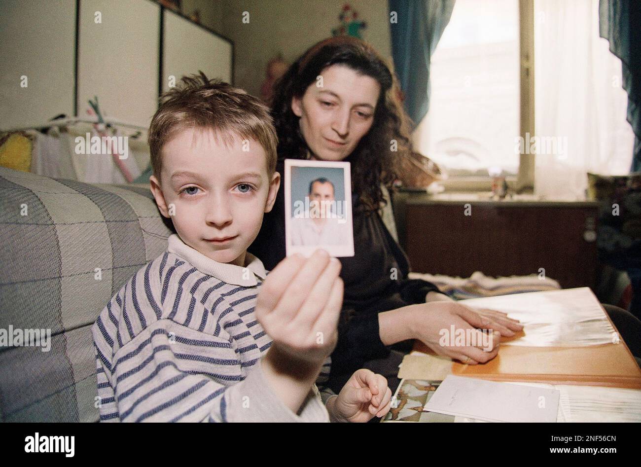 Sitting in his Sarajevo apartment, Dan Mirkov, 6, holds up a photograph ...
