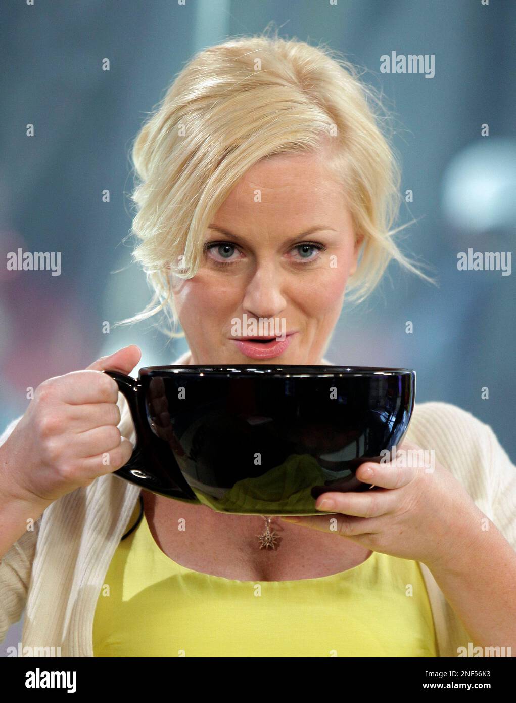 Actress Amy Poehler sips from a giant coffee cup during her appearance ...