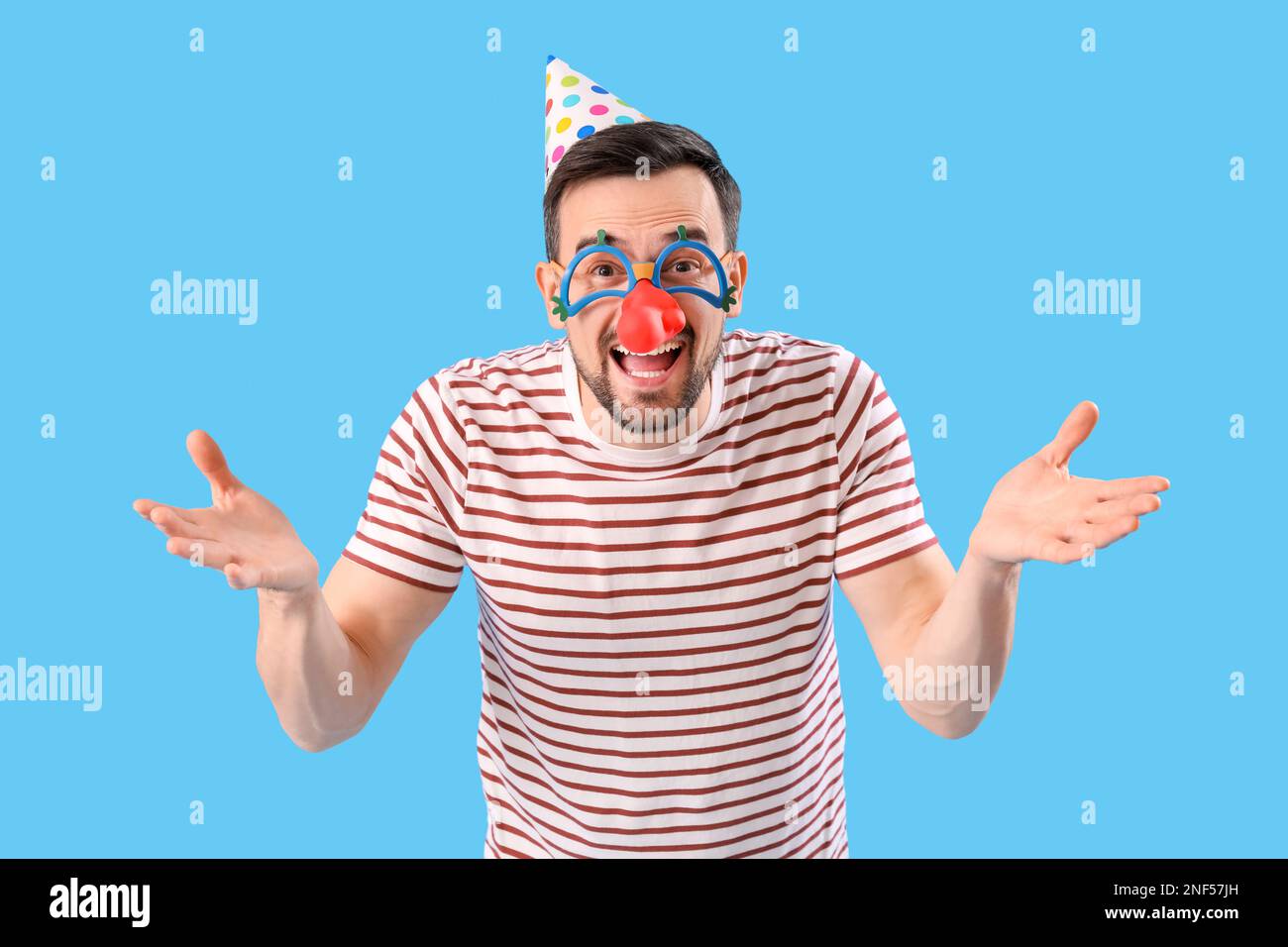 Funny young man in disguise on blue background. April Fools' Day ...