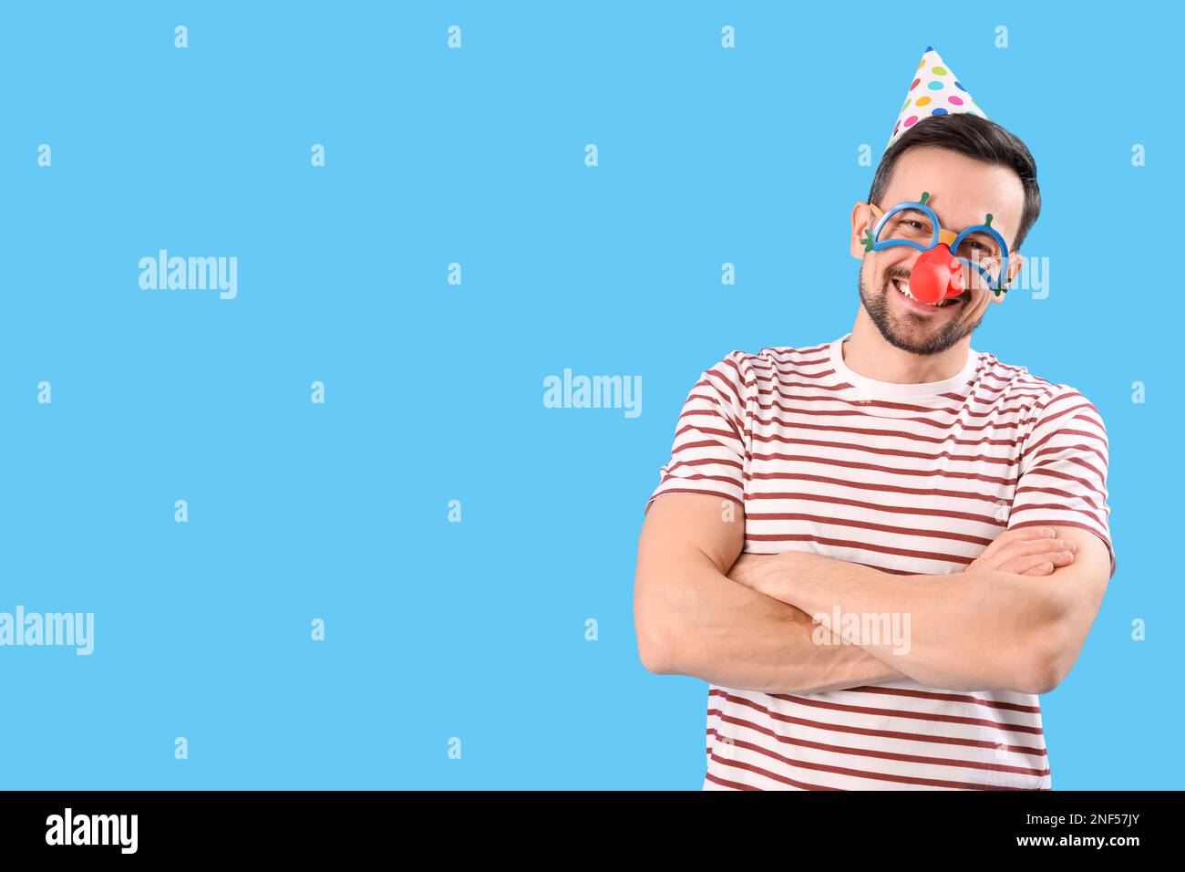 Funny young man in disguise on blue background. April Fools' Day ...