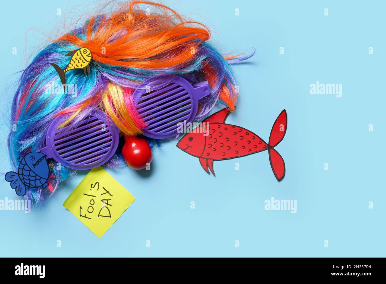 Composition with party decor and paper fishes on color background ...