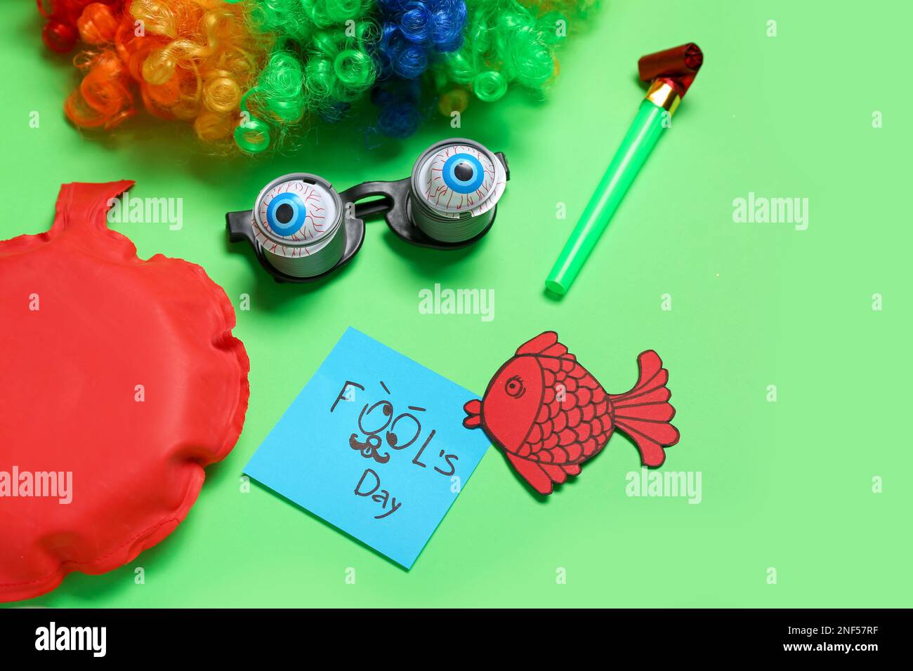 Set of party decor and sticky note with text FOOL'S DAY on green ...