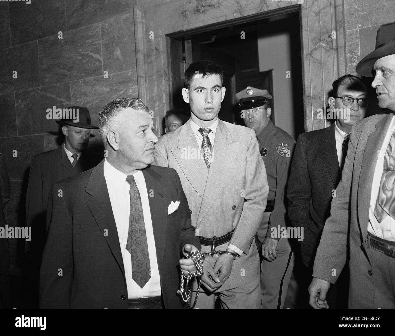 John Gilbert Graham, right, 23-year-old accused slayer, wears chains as ...