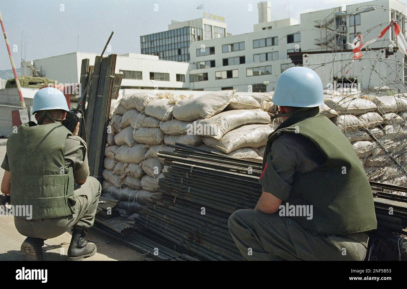 Two French United Nations soldiers take cover behind sandbags following ...