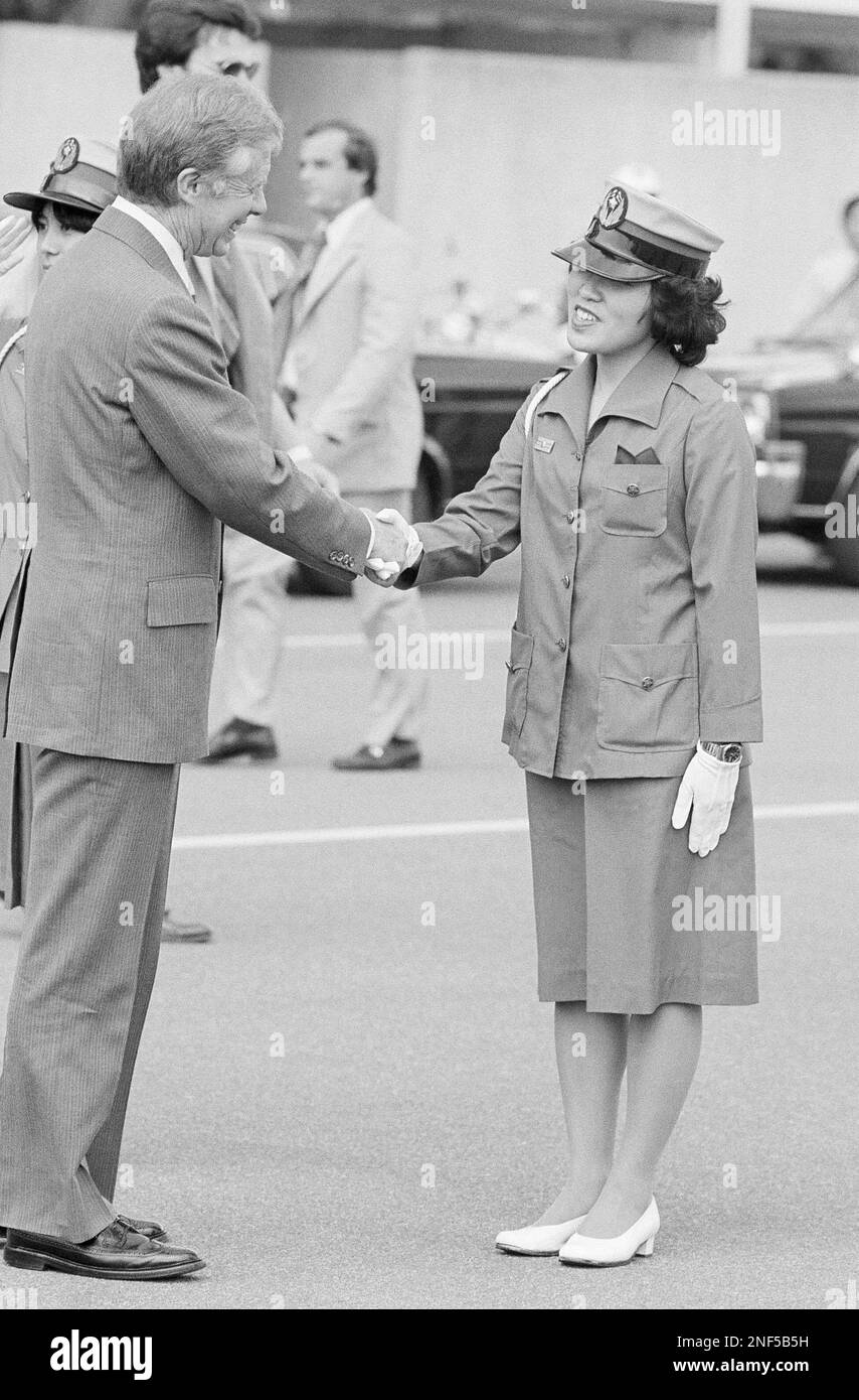 President Jimmy Carter greets and gets a smile a Japanese police woman ...