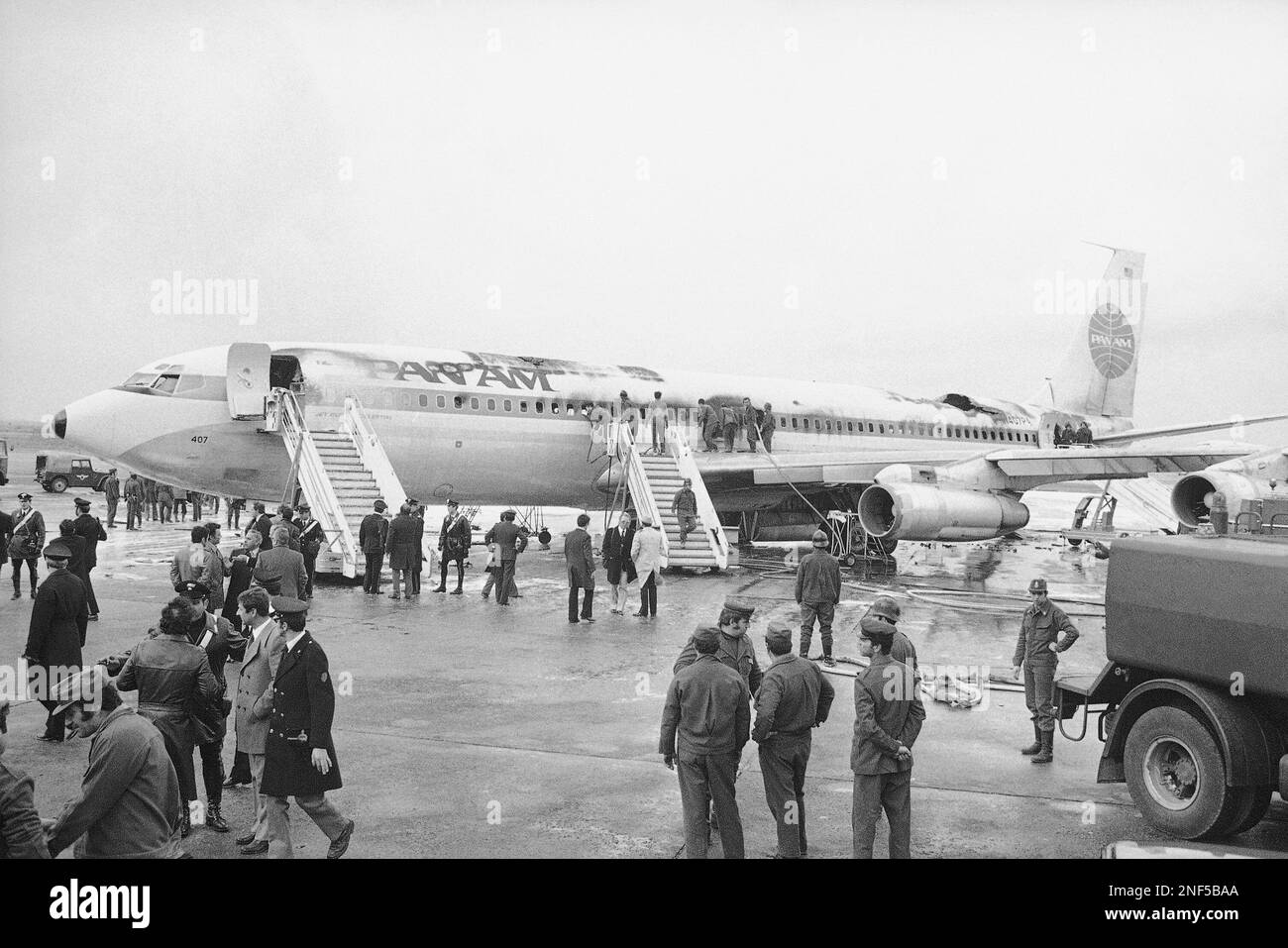 Firemen work around wreckage of Boeing 707 of the Pan Am World Airways ...