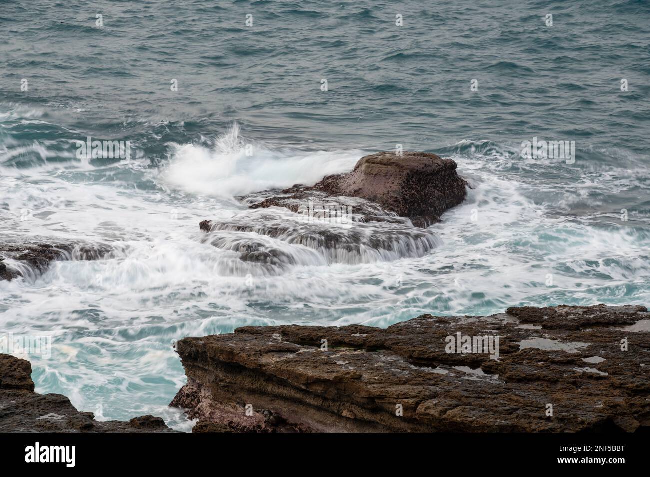 White waves lapping on the rocks. A symbol of hard work and strength ...