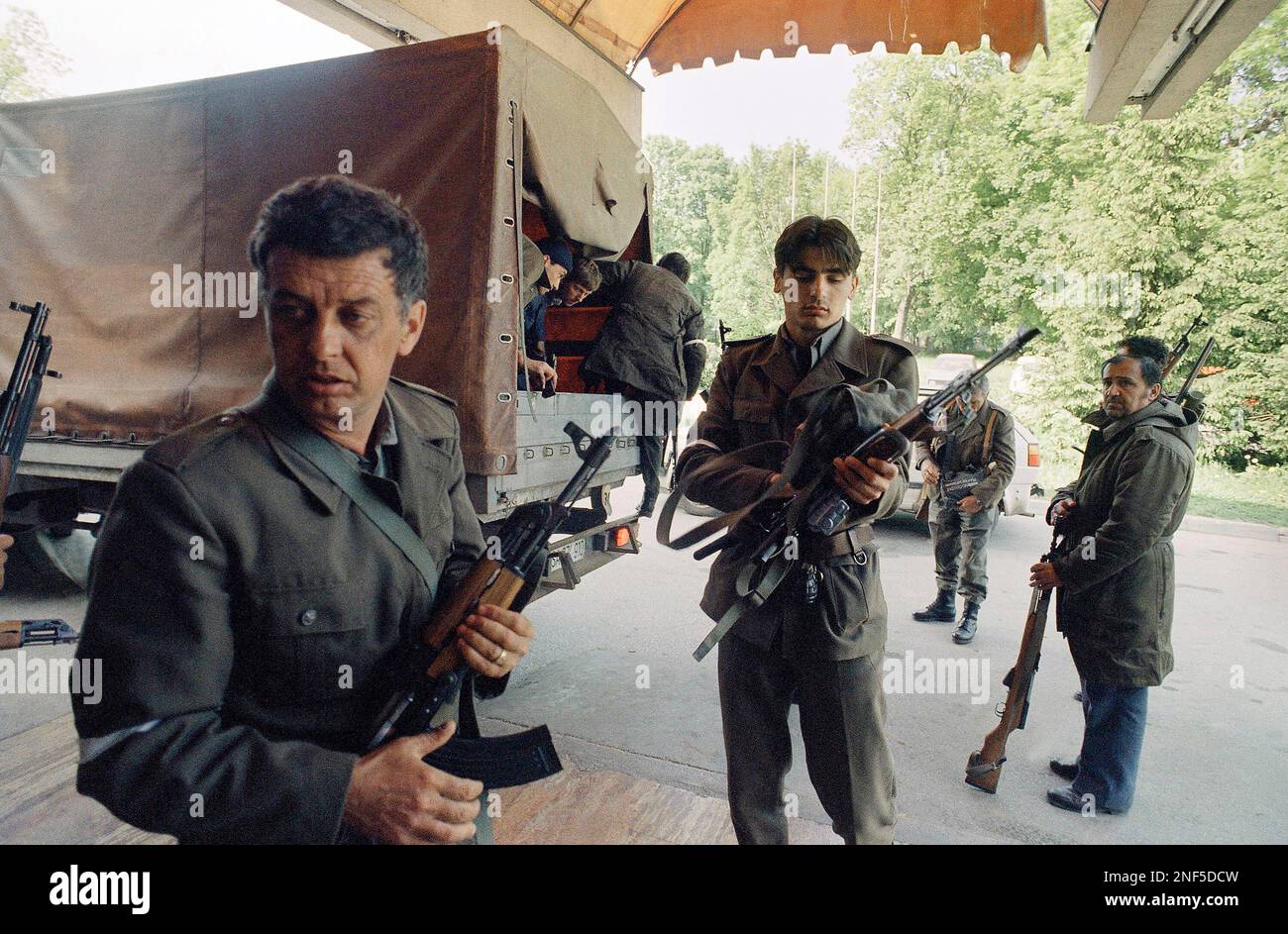 Soldiers from the Yugoslav National Army unload weapons from a truck on ...