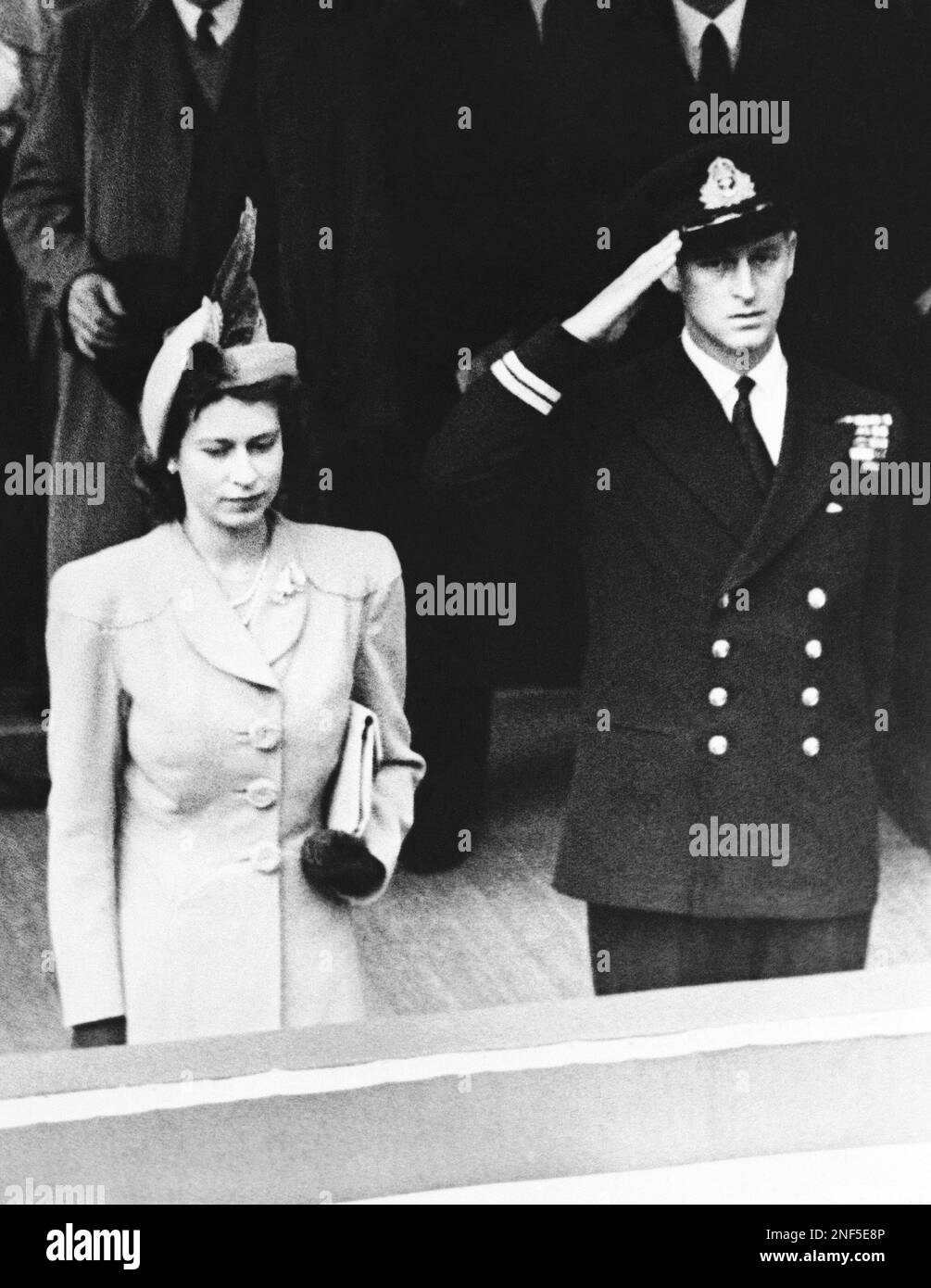 Princess Elizabeth, left, and her fiancé, Lt. Philip Mountbatten, right, watch the Cunard White ...