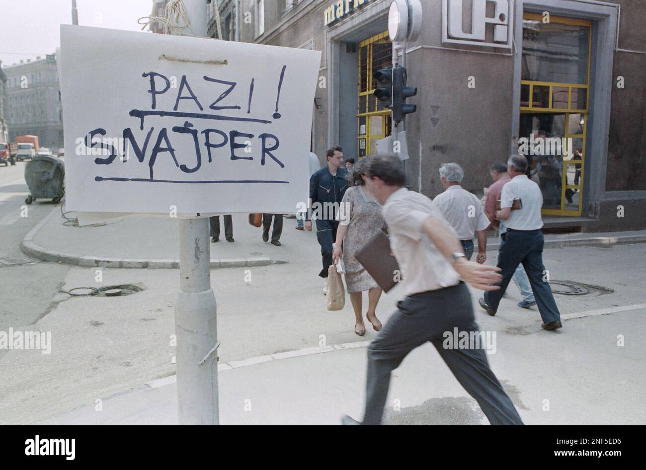 People rush to cross an intersection on Saturday, July 25, 1992 in Downtown Sarajevo, where a ...