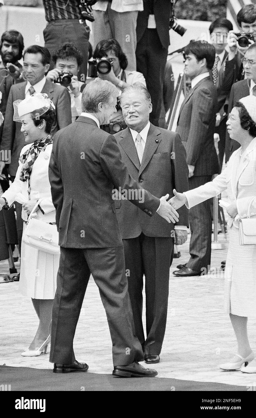 Pres. Jimmy Carter, left, shakes hands with Mrs. Shigeko Ohira, right ...