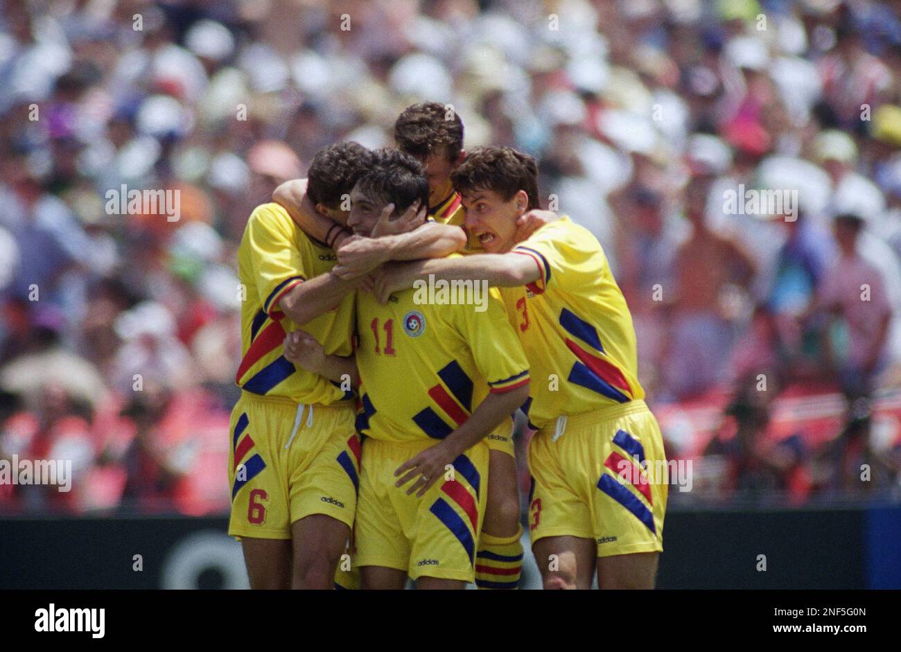 Romanian midfielder Ilie Dumitrescu (11) is mobbed by teammates ...