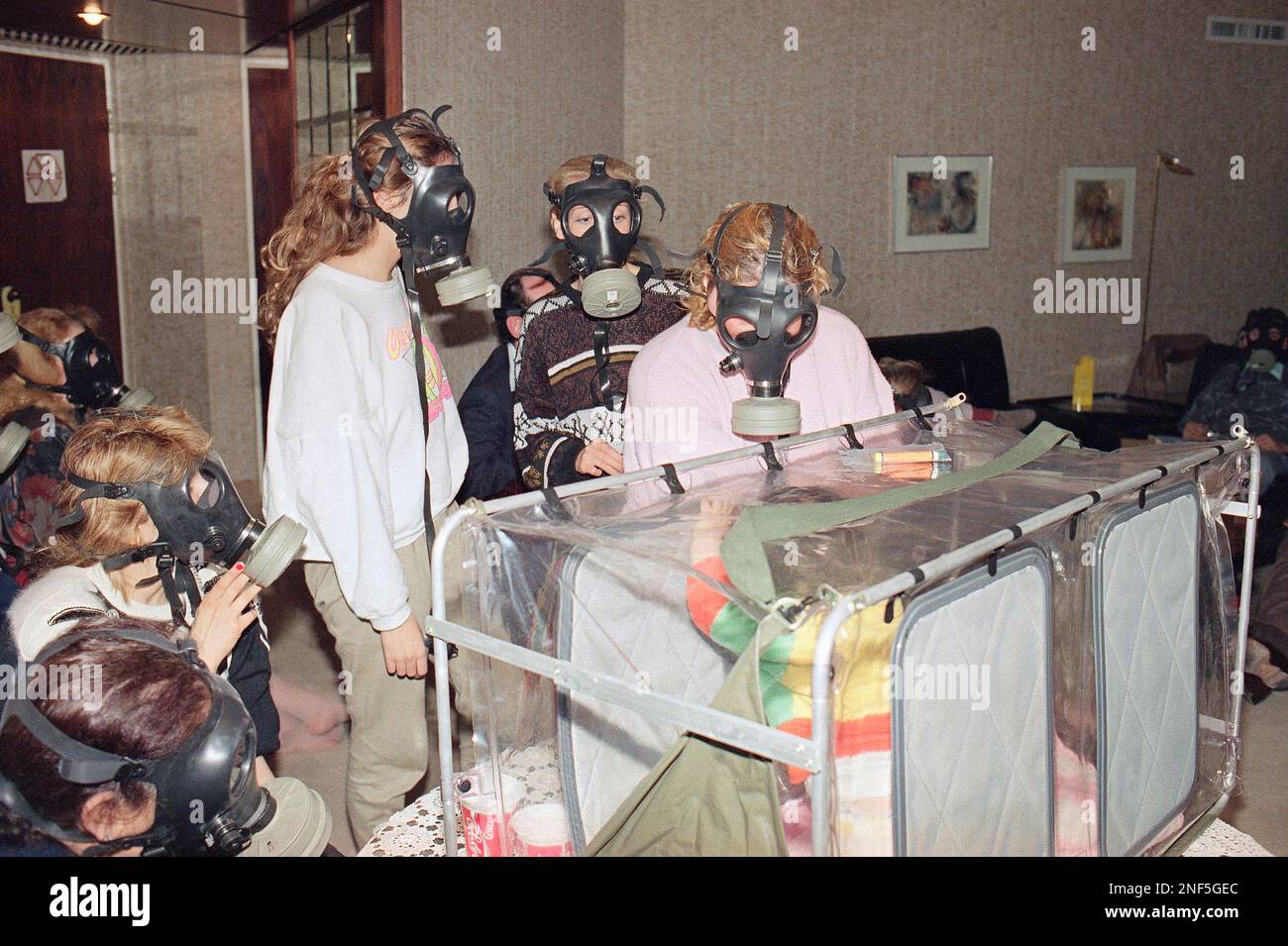 A mother wearing her gas mask, inside a “sealed air raid shelter ...