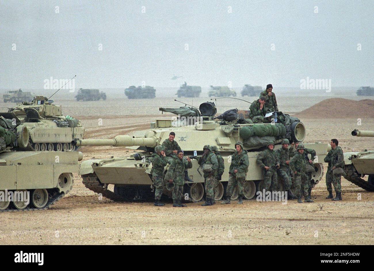 Troops from the Army’s 1st Infantry Division lean on an M1A1 Abrams ...