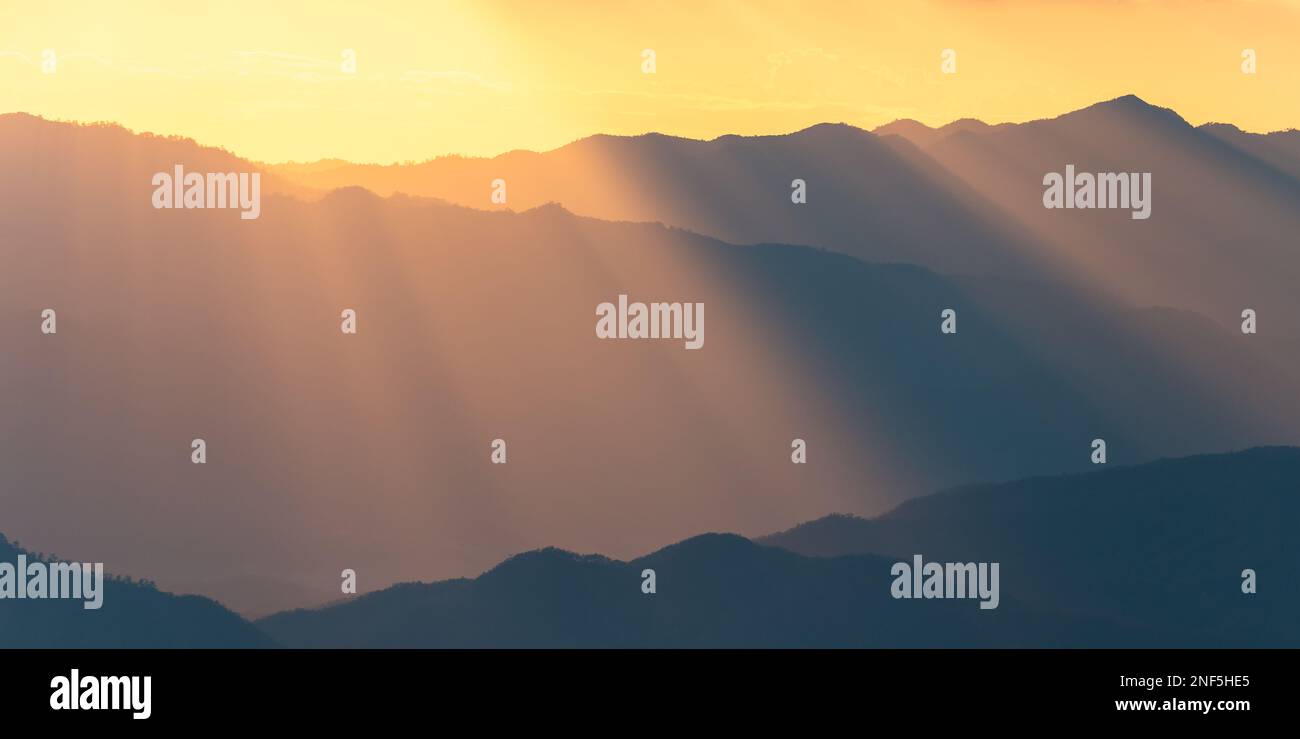 Panoramic scene of sunlight shining through the mountain range at ...
