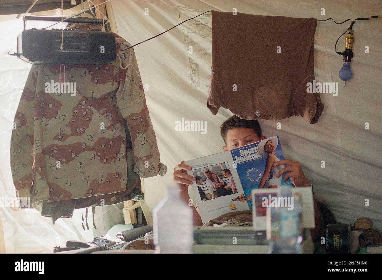 Pfc. Mike Kurtz of Riddle, Ore., catches up on the swimsuit issue of ...