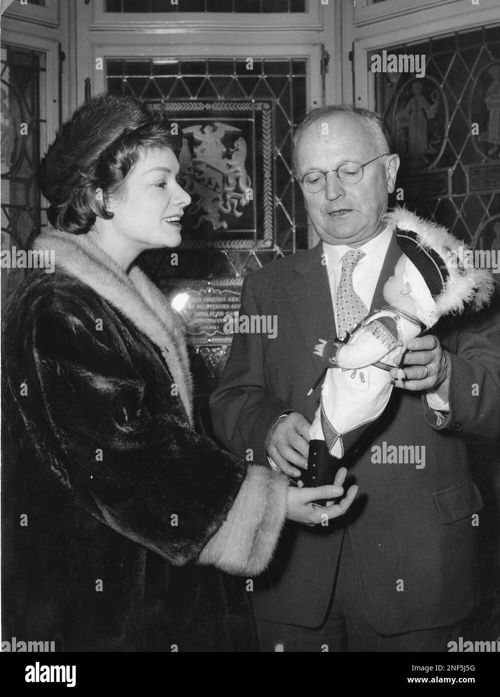 West German actress Ruth Leuwerik, takes a look at a puppet held by ...