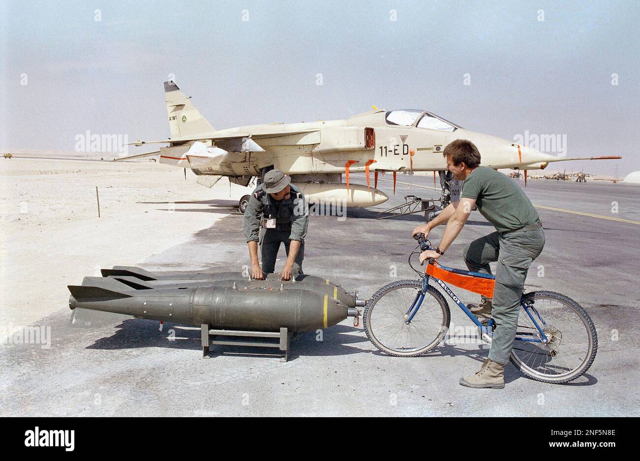 A weapons specialist prepares to load a 250-kilogram bomb on a Jaguar ...