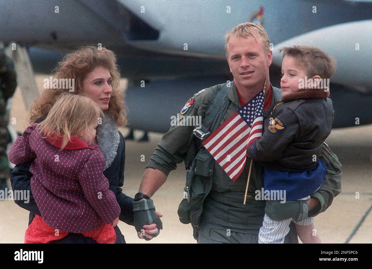 Air Force Captain Steve Tate holds his son, Patrick, as he and his wife ...