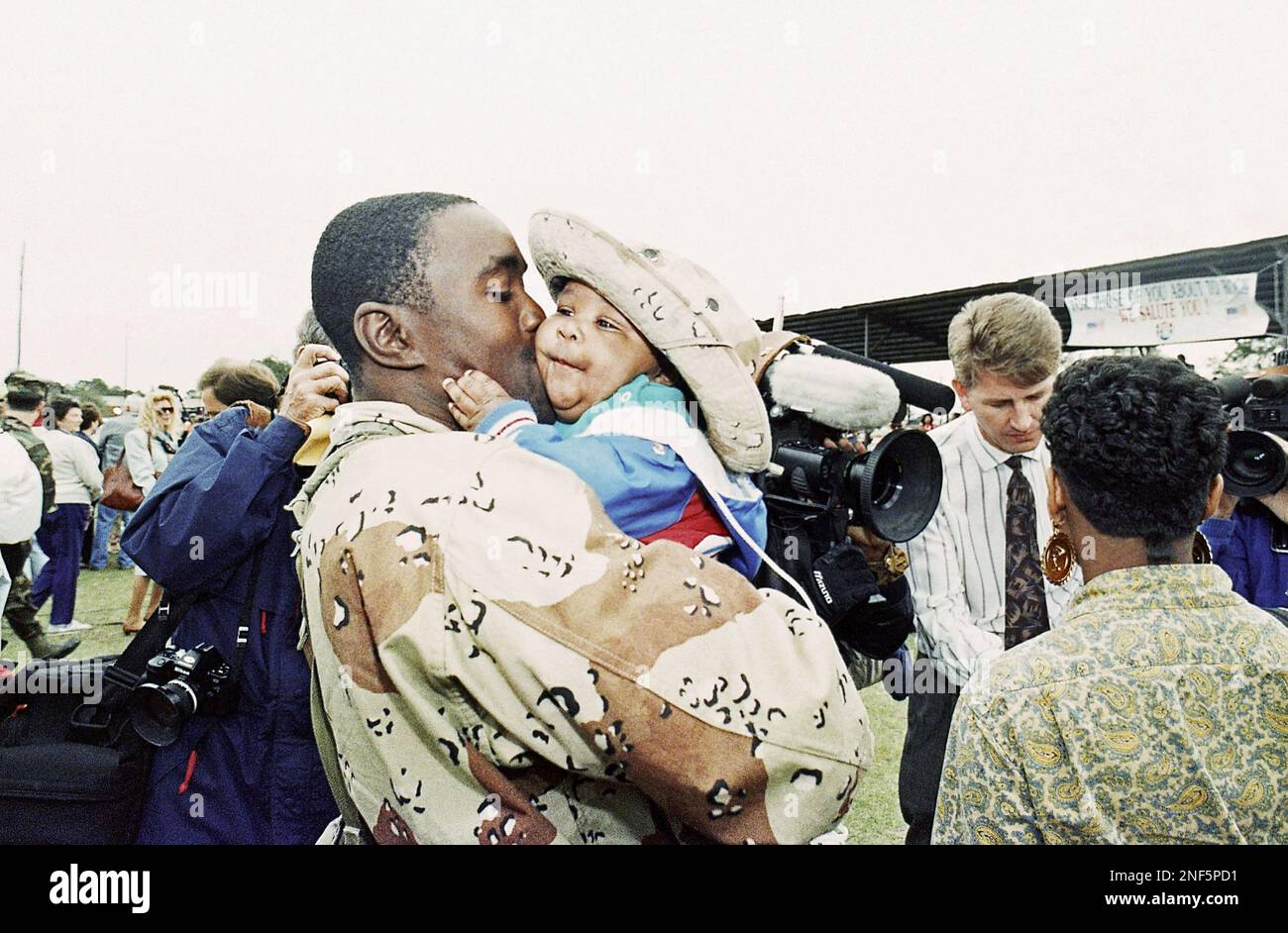 Spc. Dave Bell gives his five-month-old son Dave Jr. a kiss after ...
