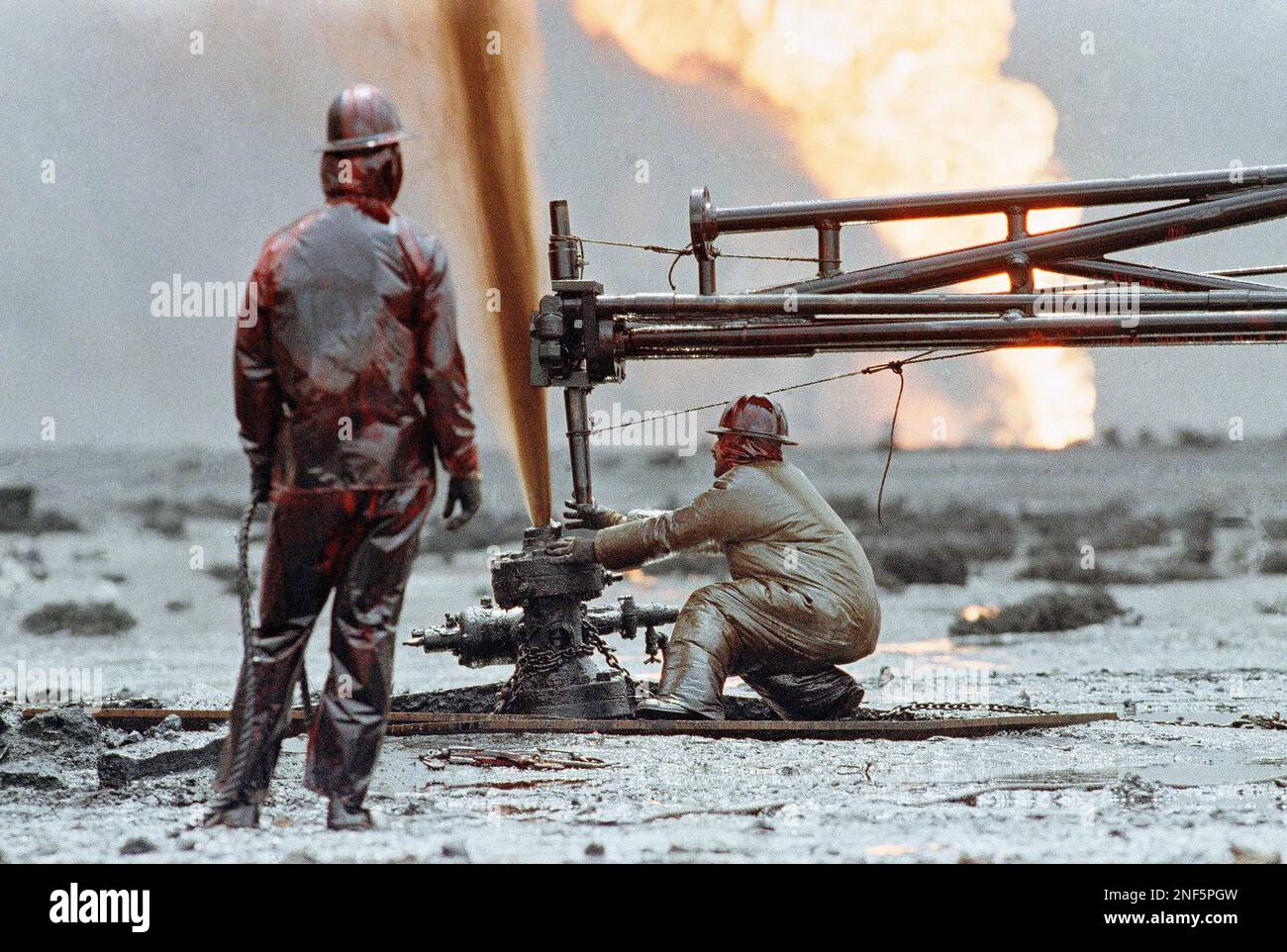 Brian Krause, of the Red Adair Co., guides an oil well capping device ...