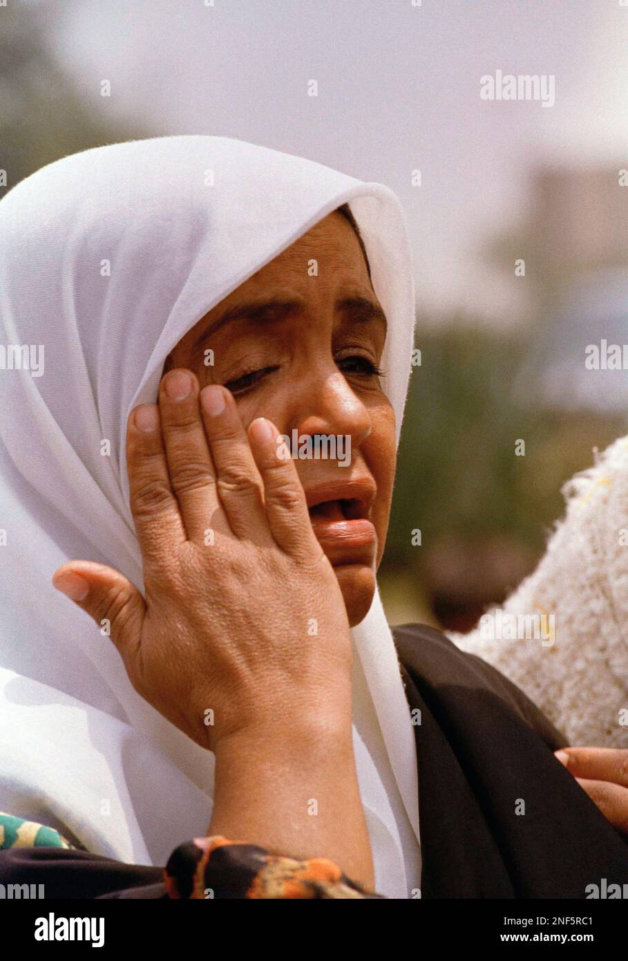 A Kuwaiti woman wipes a tear as she participates in a demonstration ...