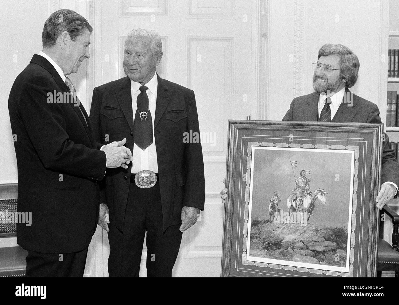 President Ronald Reagan chats with artist Olaf Wieghorst, center, who ...