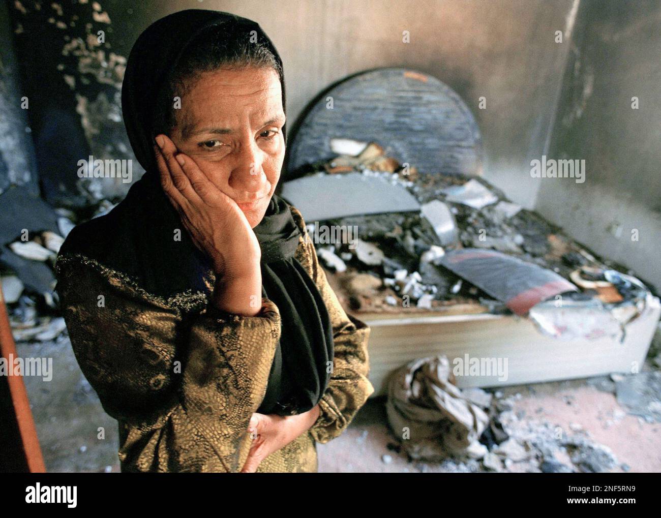 Zaneb Borkee reacts as she looks around her charred and wrecked Kuwait ...