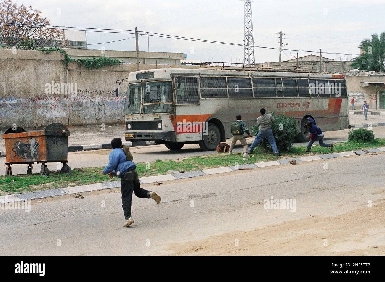 Palestinian youths stone an Israeli bus on a main street in Gaza City ...