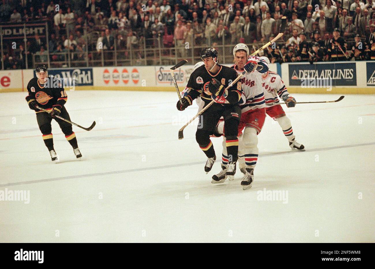 Vancouver Canucks left wing Greg Adams, left, collides with New York ...