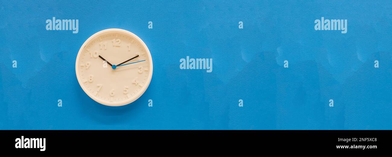 White big analogue plain wall clock on trendy pastel blue background ...