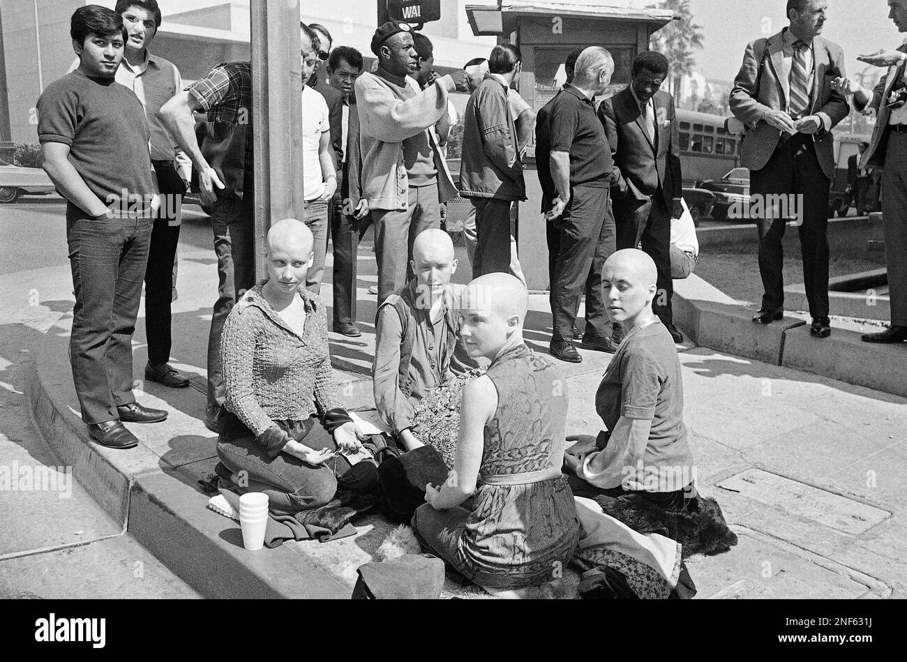 Four young women members of the Charles Manson "family" kneel on the ...
