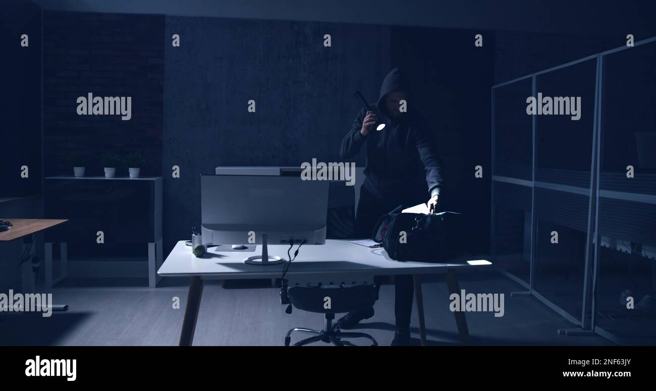 Thief Stealing Computer From Office At Night Stock Photo - Alamy