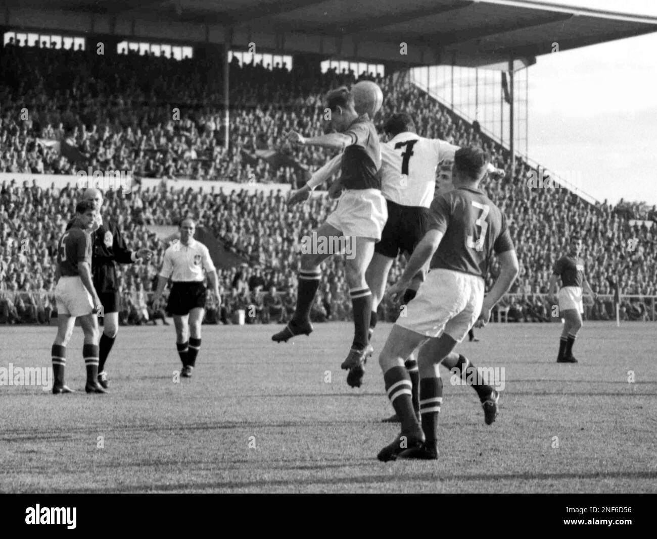 Austrian forward Walter Horak, centre no.7, jumps and gets his head to ...