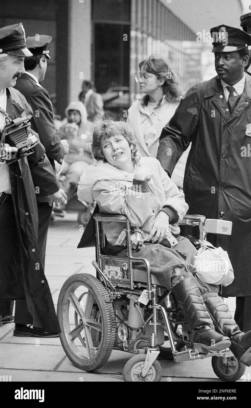 Police officers surround a demonstrator in a wheelchair during a ...