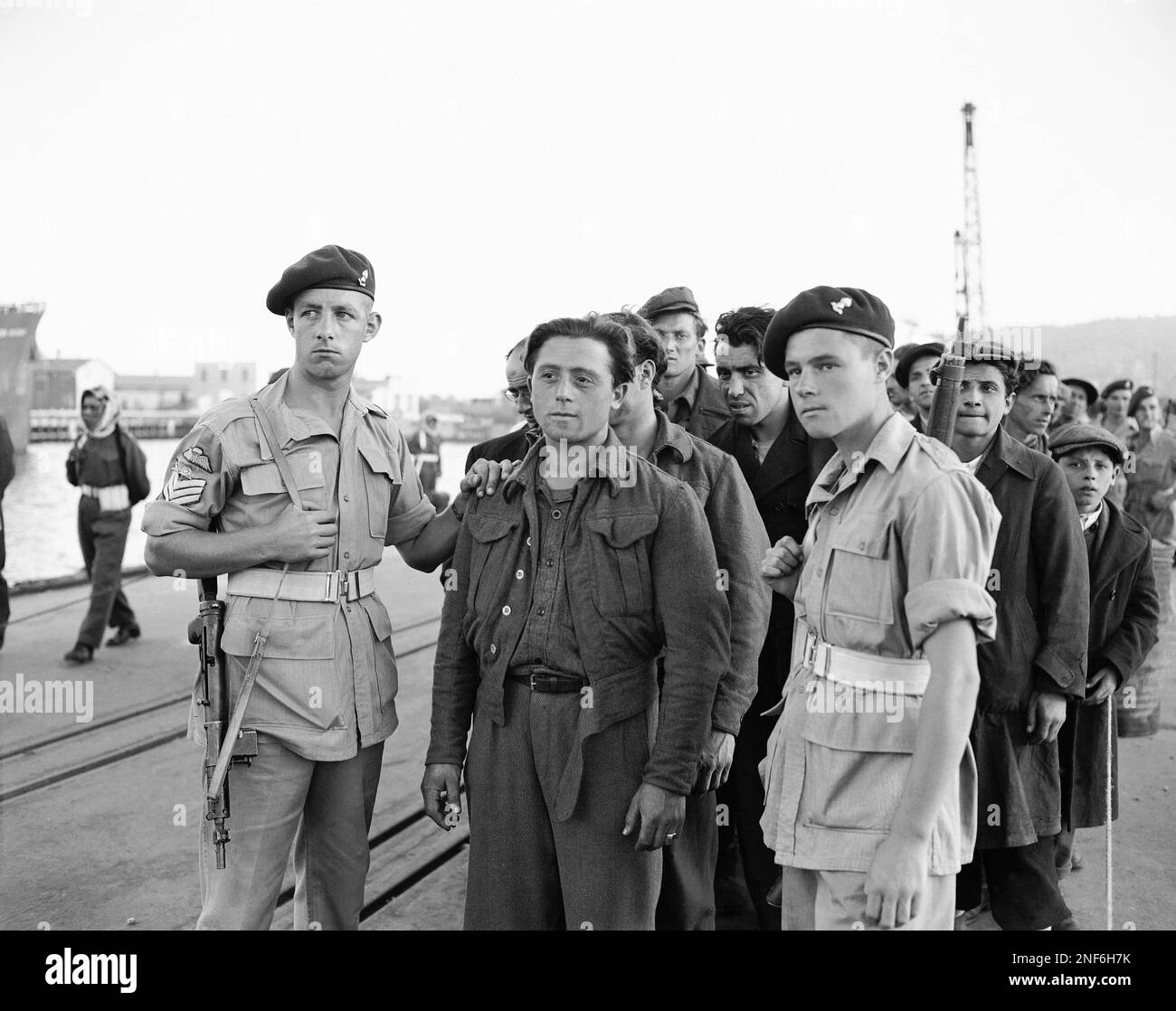 A British soldier guards some of the Jewish male refugees as they line ...
