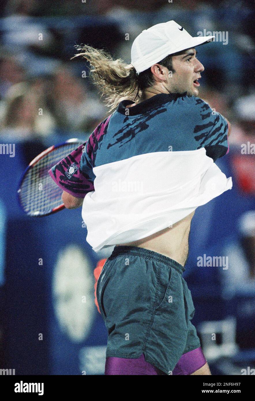 Andre Agassi of Las Vegas, Nevada, returns the ball towards Jim Courier ...