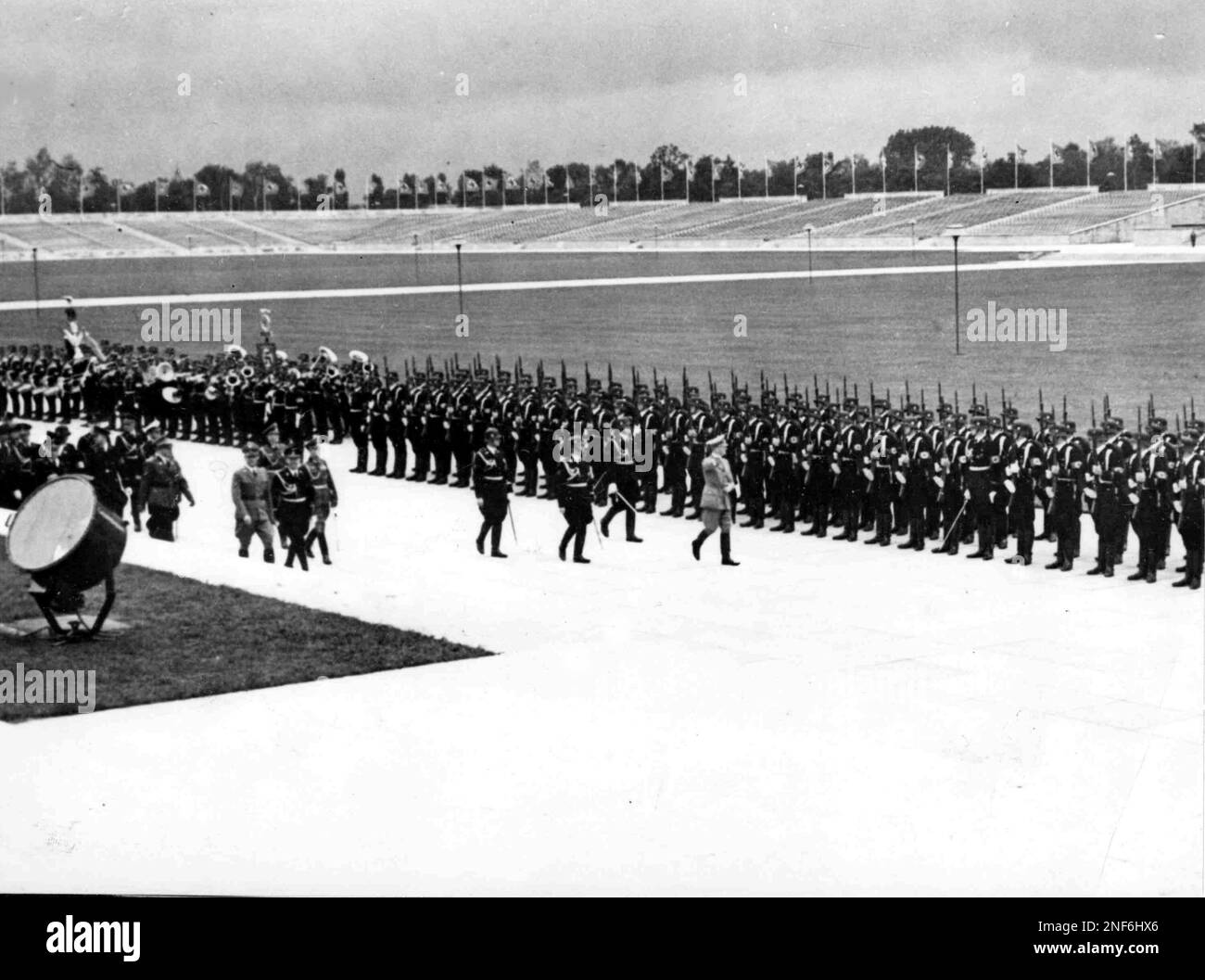 German Chancellor Adolf Hitler, in light uniform, salutes as he reviews ...