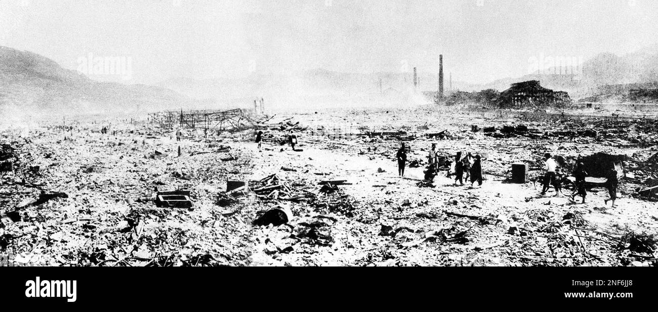 Japanese workers carry away debris in a devastated area of Nagasaki, an ...
