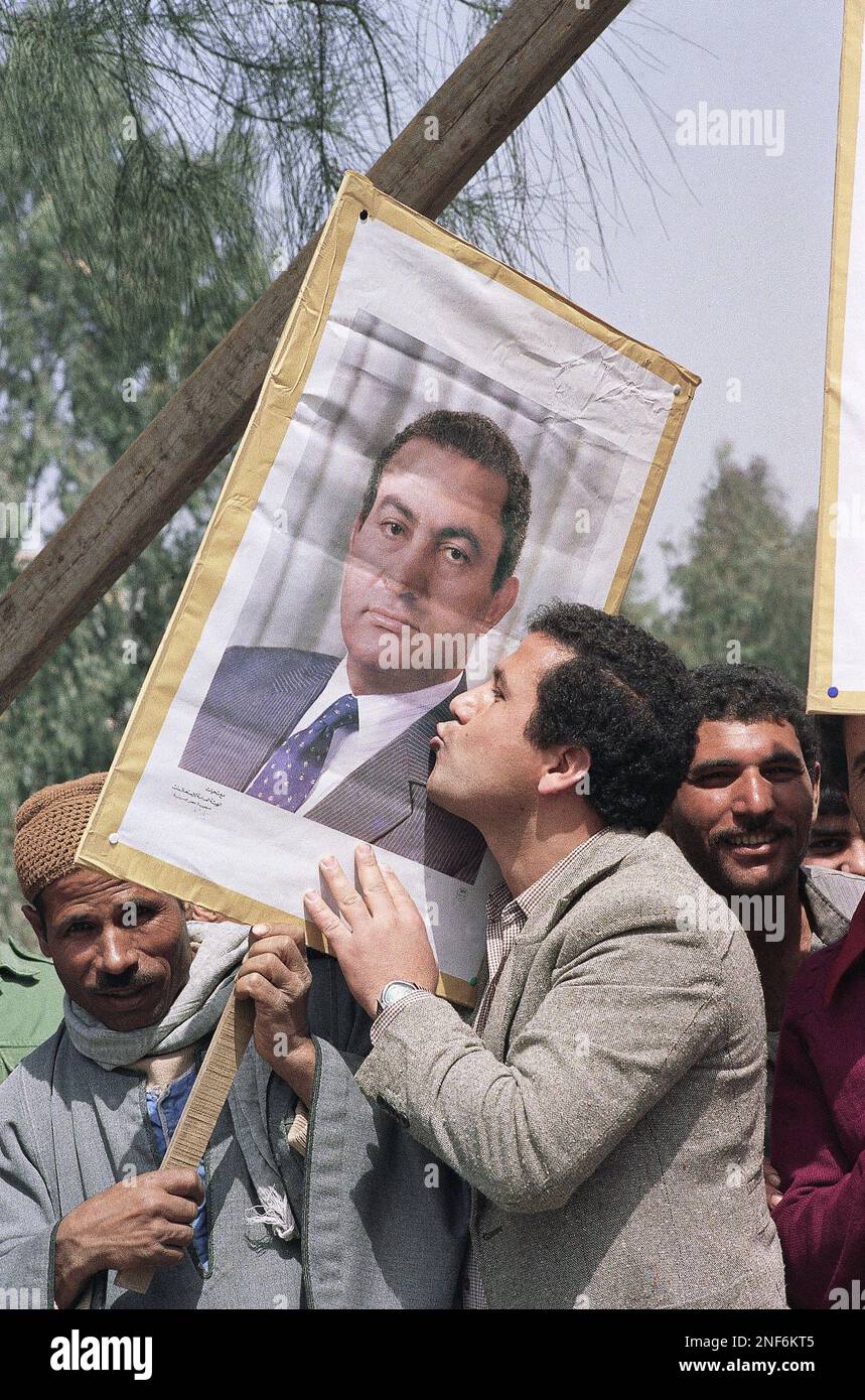 An Egyptian shows his support for Pres. Hosni Mubarak by kissing a ...