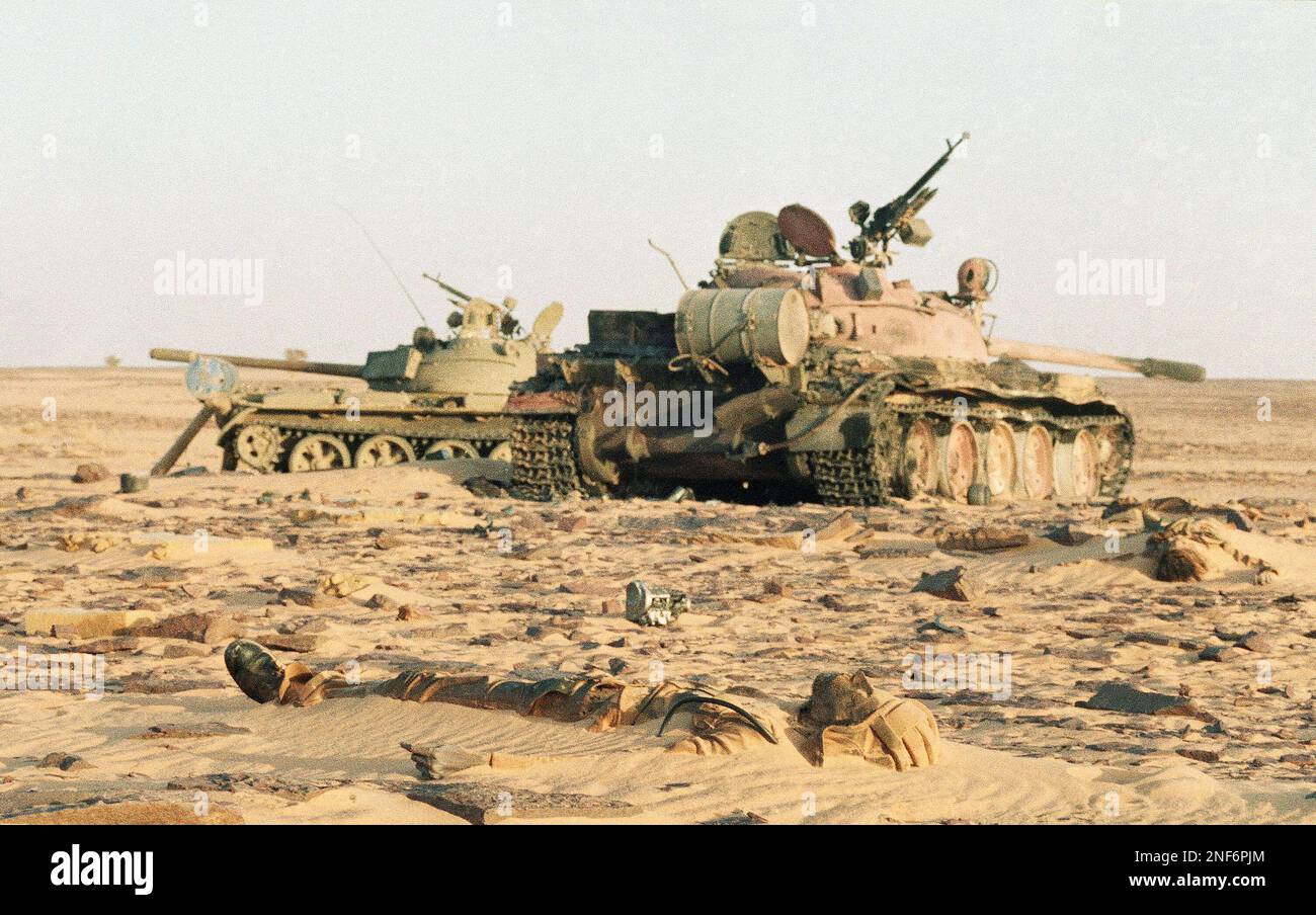 The body of a Libyan tank driver lies partly buried in the sands of the ...